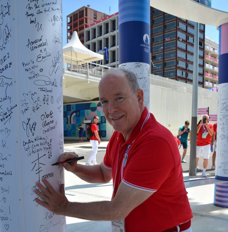 Prince Albert II signs the Peace Wall in the Olympic Village